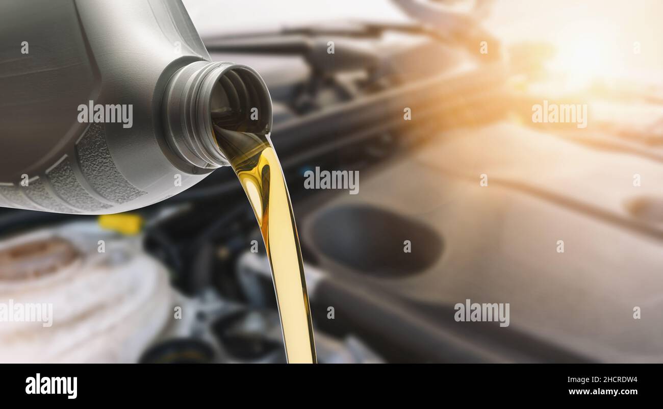 Pouring oil to car engine, Fresh oil poured during an oil change to a ...