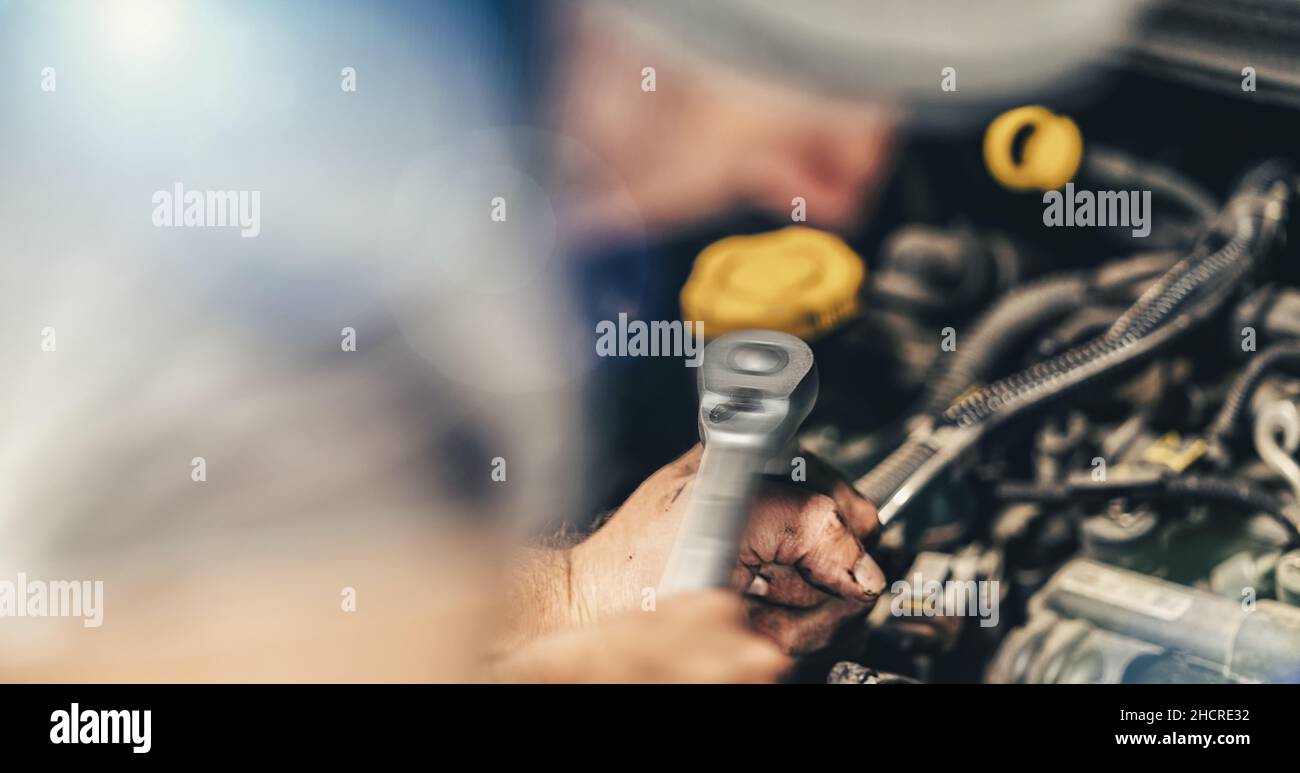 Auto mechanic working on car engine in mechanics garage. Repair service ...