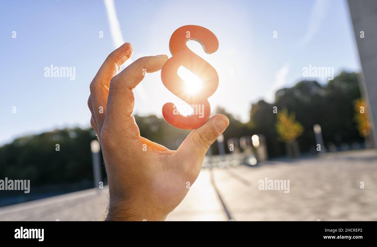 Hand holds paragraph symbol in to the sun as sign for Justice - lady ...