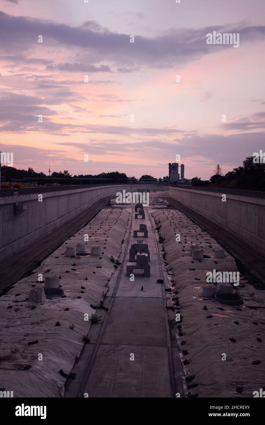 Vertical shot of purple sunset over a large cement pathway lined with ...
