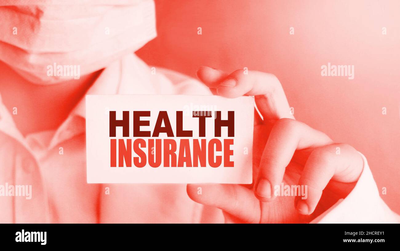 Health insurance words on the card in hands of Medical Doctor ...