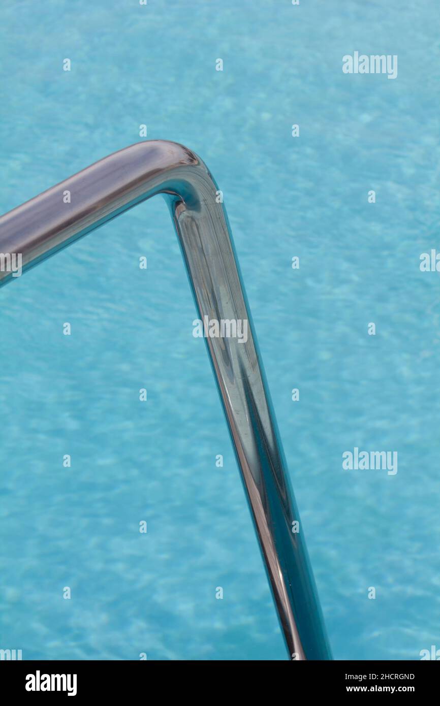 Abstract of the chrome steps rail of the outside swimming pool on the ...