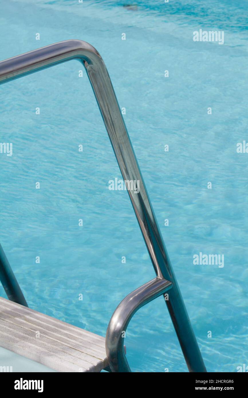 Detail of the steps and chrome hand rail of the outside swimming pool ...