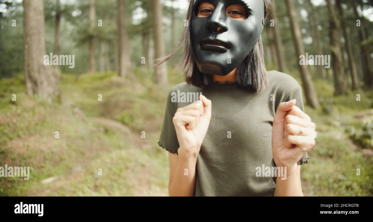 Indian female with a festive mask in the forest Stock Photo - Alamy