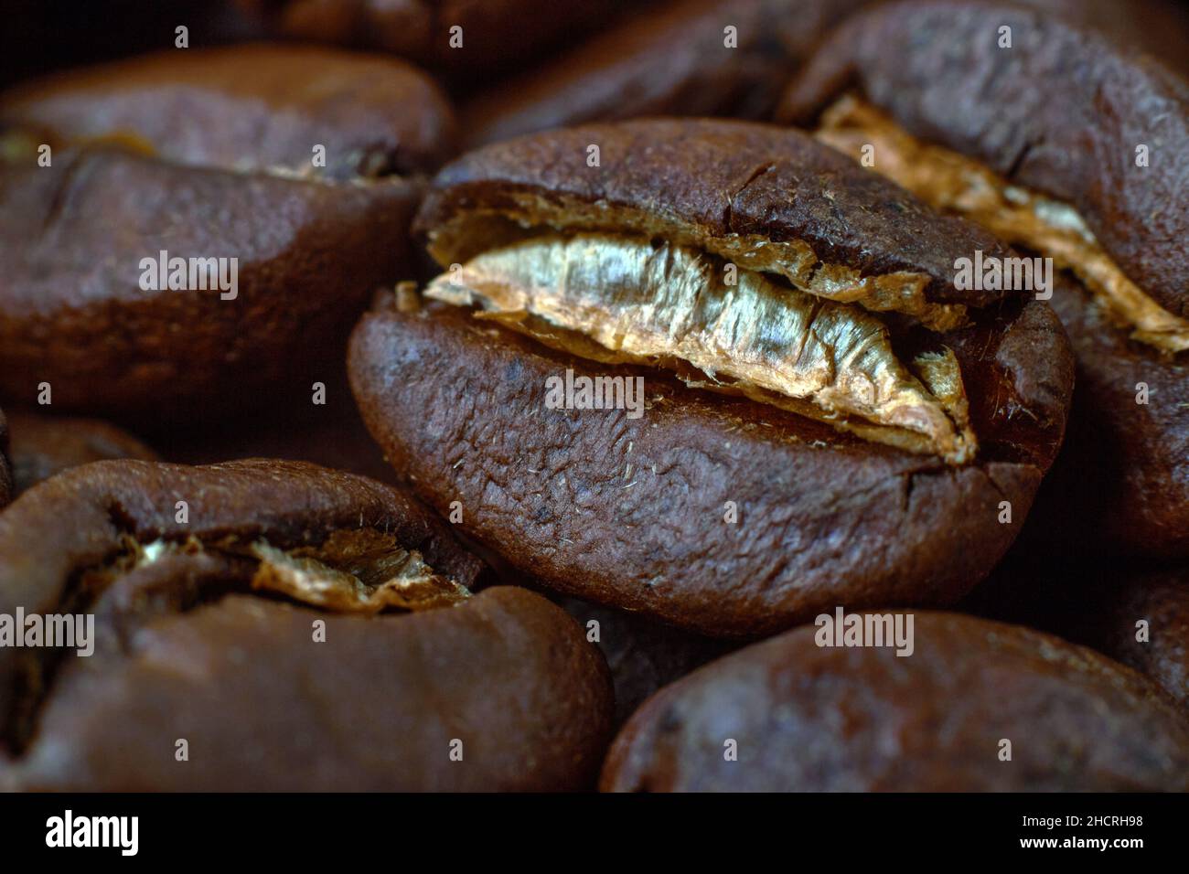 Roasted coffee beans scattered in random order on a dark background ...