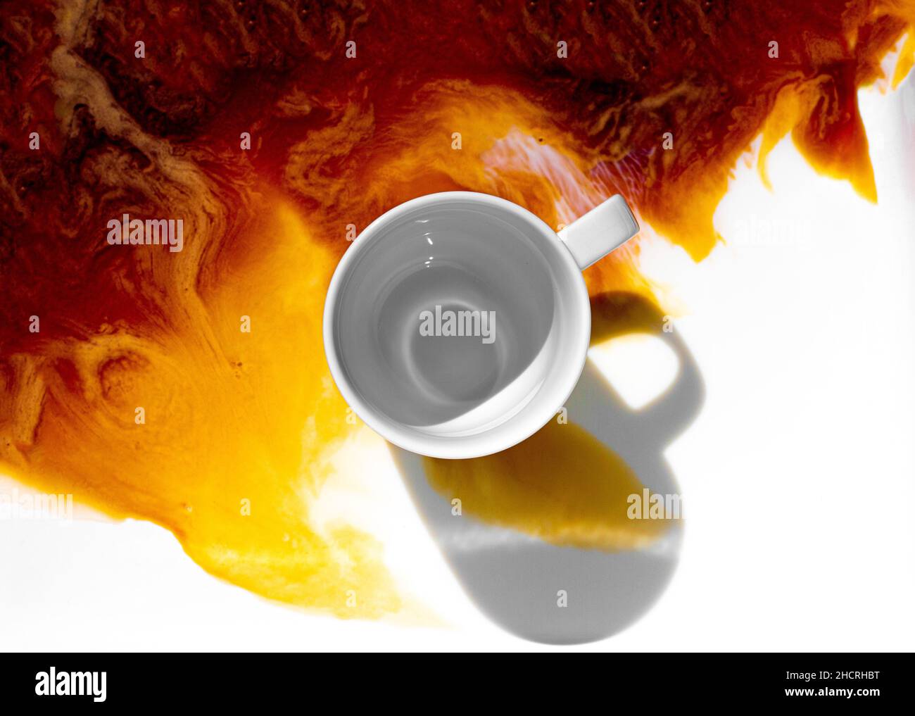 Top view of an empty white ceramic mug next to spoiled coffee on a ...