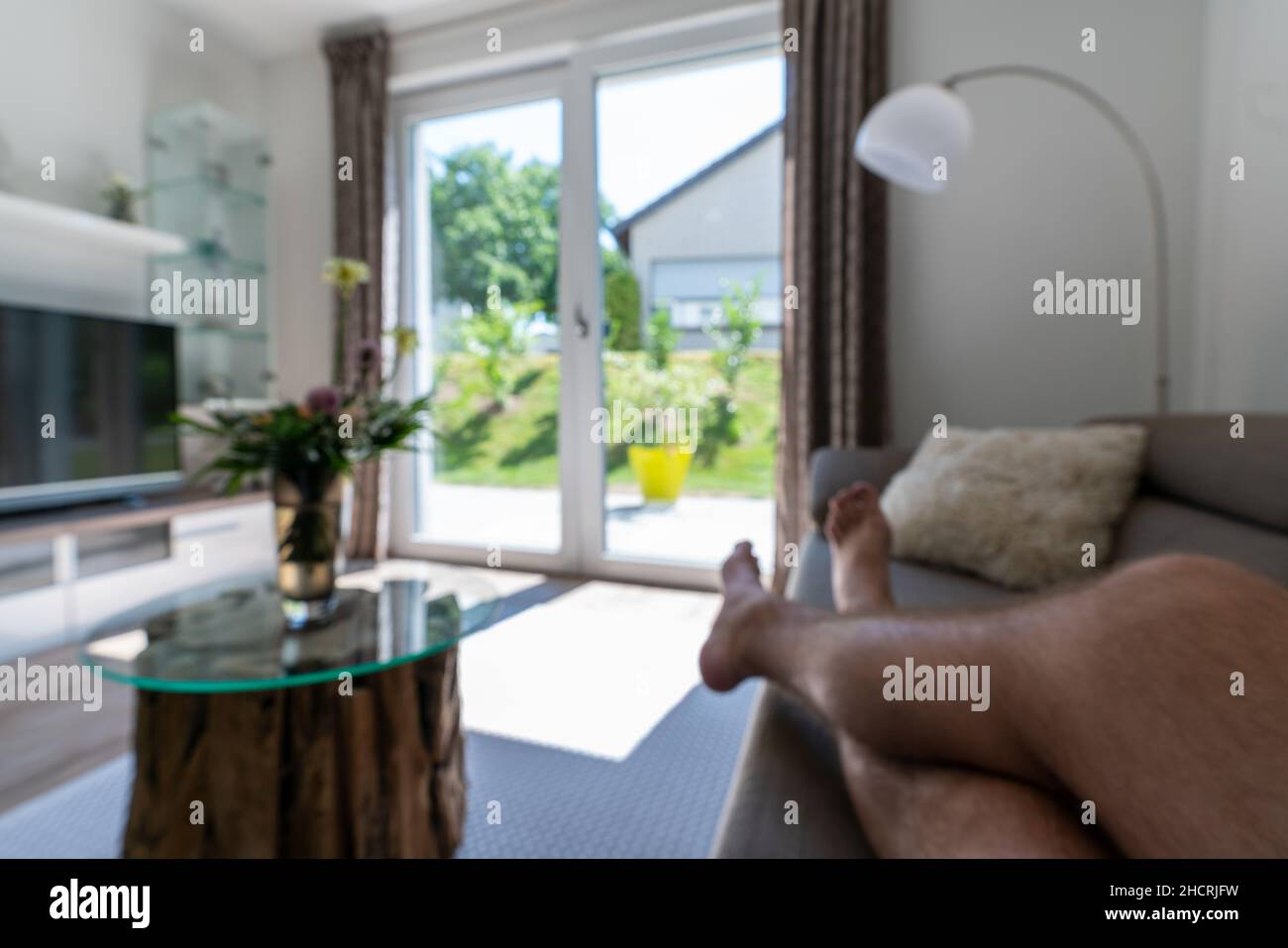 blur image of modern living room at home with man relaxing at the couch ...