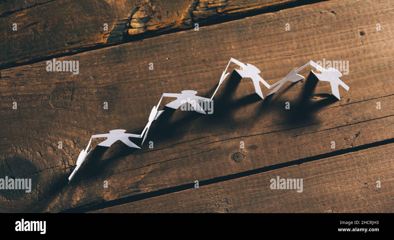 people cut out of paper on wooden table background Stock Photo - Alamy