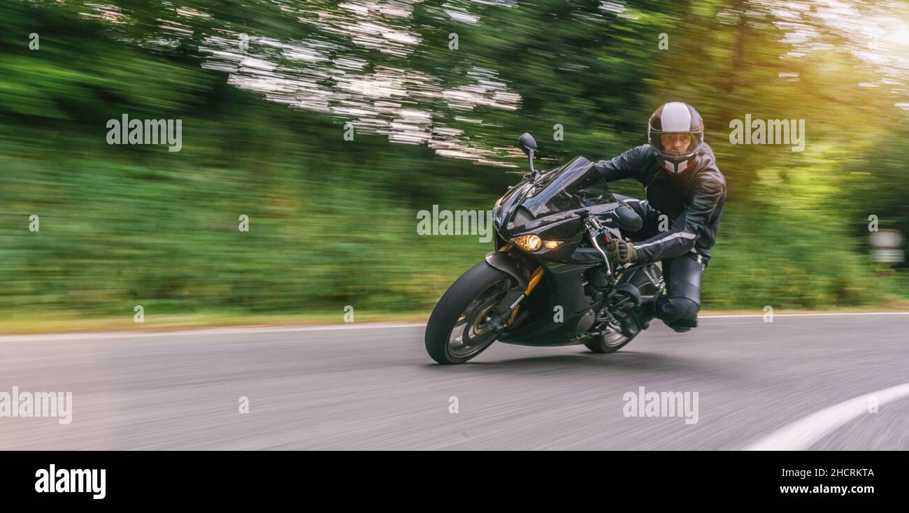 motorbike riding on the forest road in a curve. driving on the empty ...