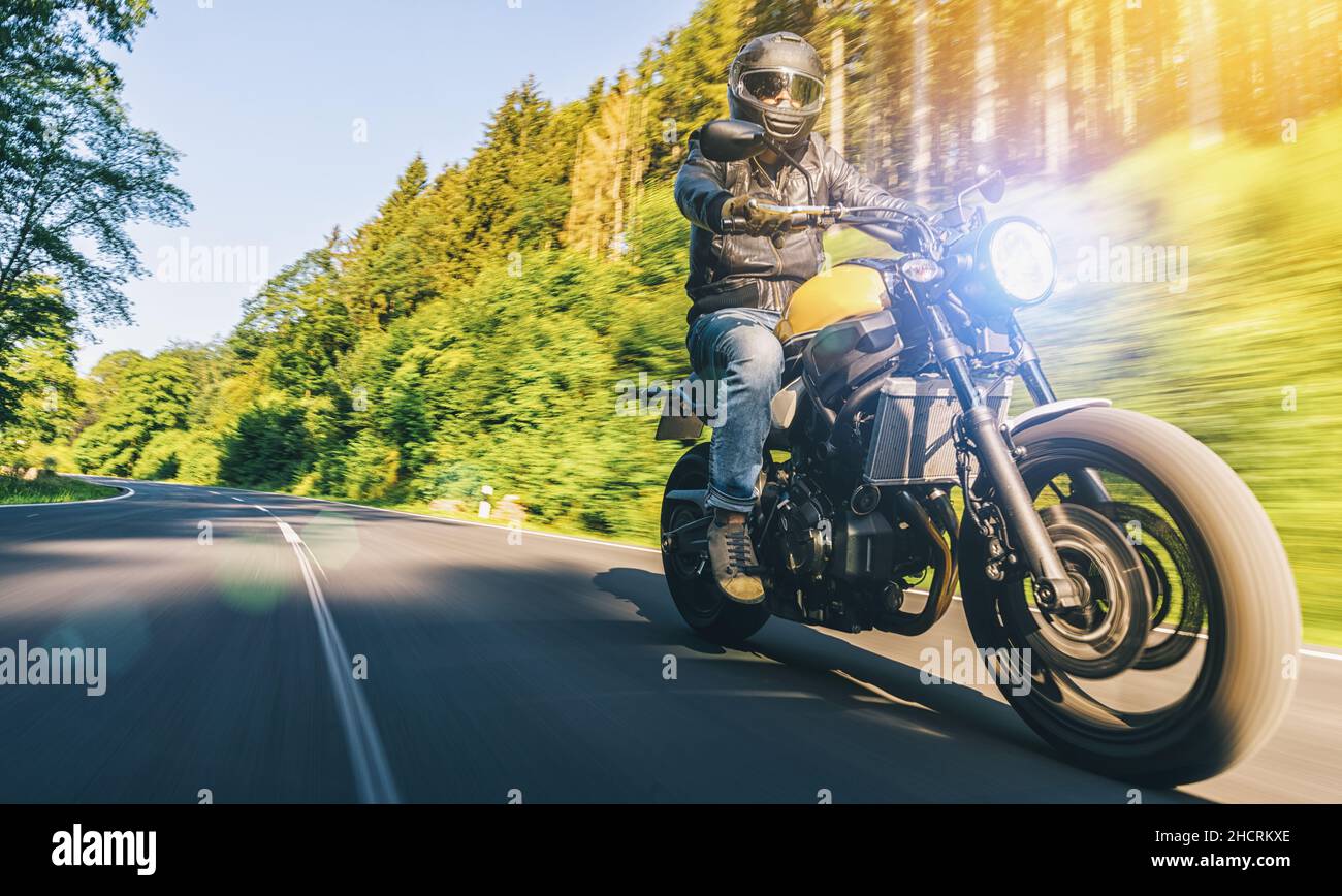 modern scrambler motorbike on the forest road riding. having fun ...