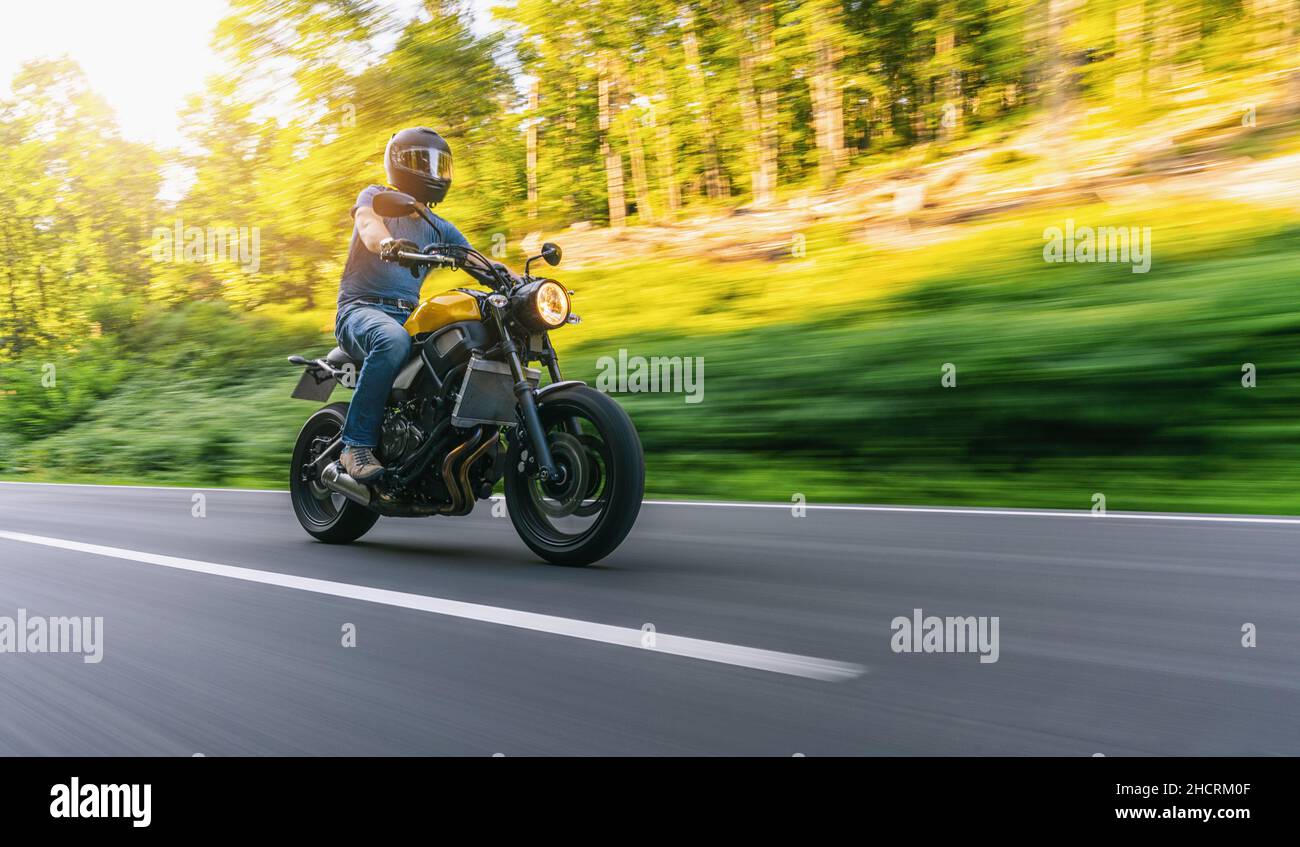 motorbike on the forest road riding at sunset. having fun driving the ...
