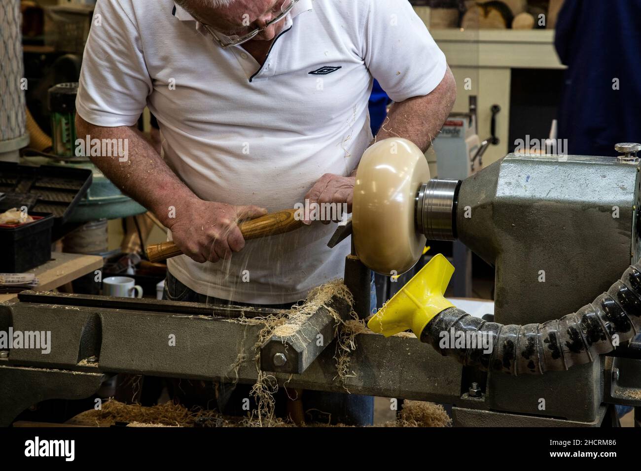 Close up of a wood turner using a chisel to craft a bowl being turned ...