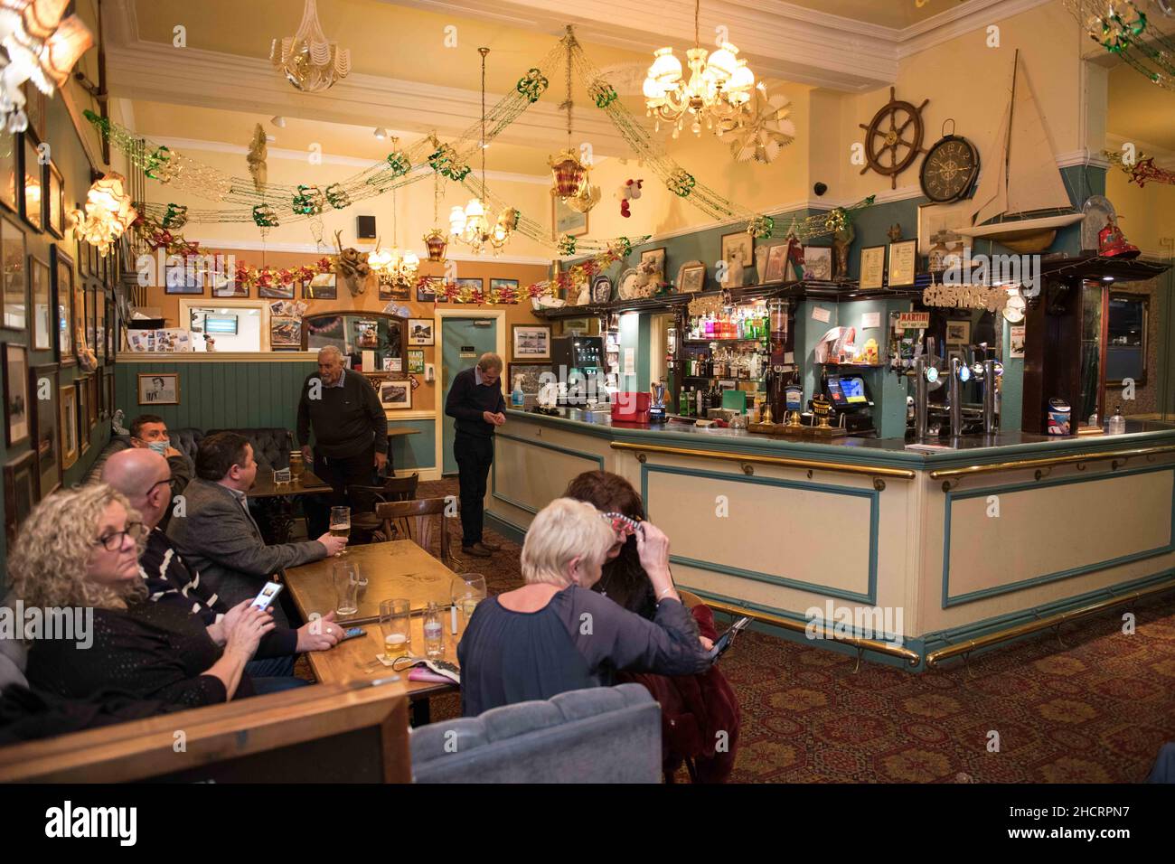 Drinkers sit at tables inside the Queens pub in Swansea on New Years ...