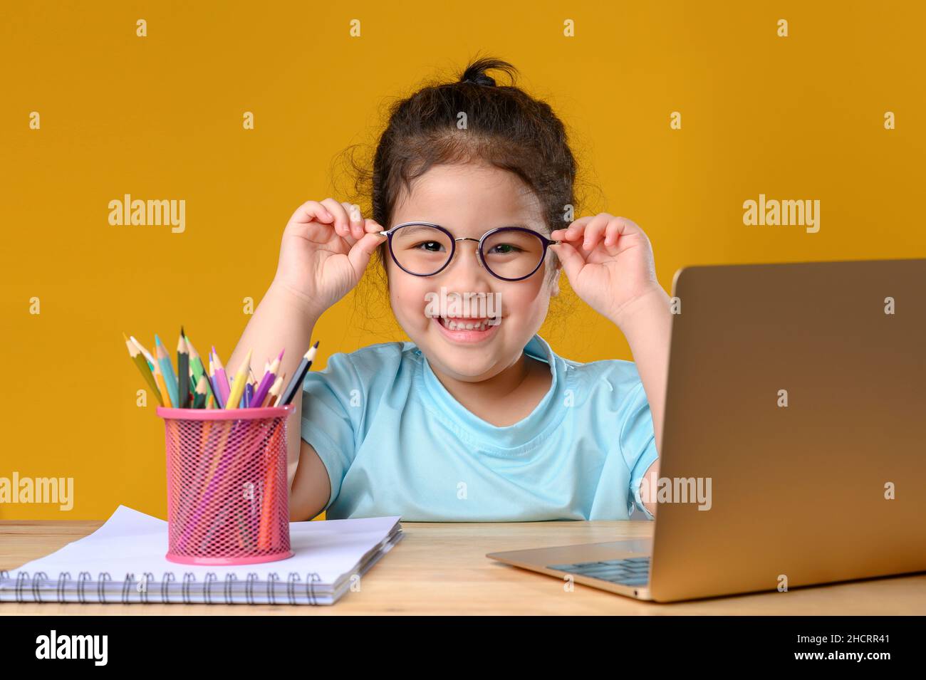 A Happy little asian girl studying online learning class with online ...