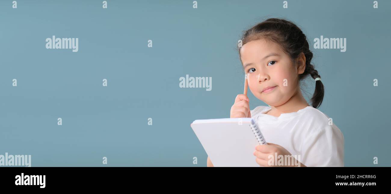 Thinking a cute little asian girl on blue background. Child thinking ...