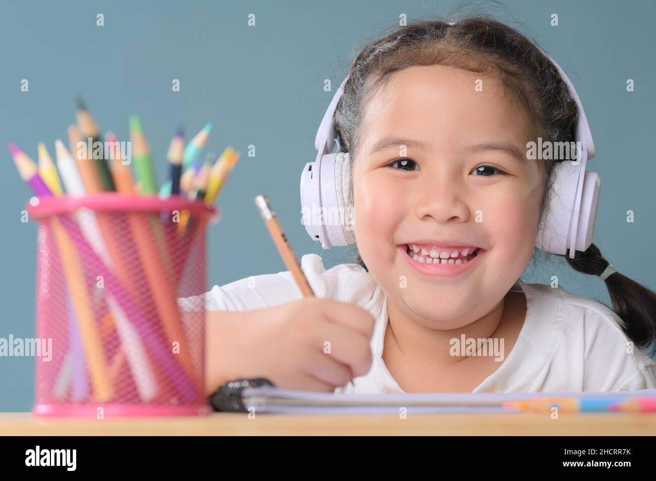 A Happy little asian girl studying online learning class with online video call zoom teacher at ...