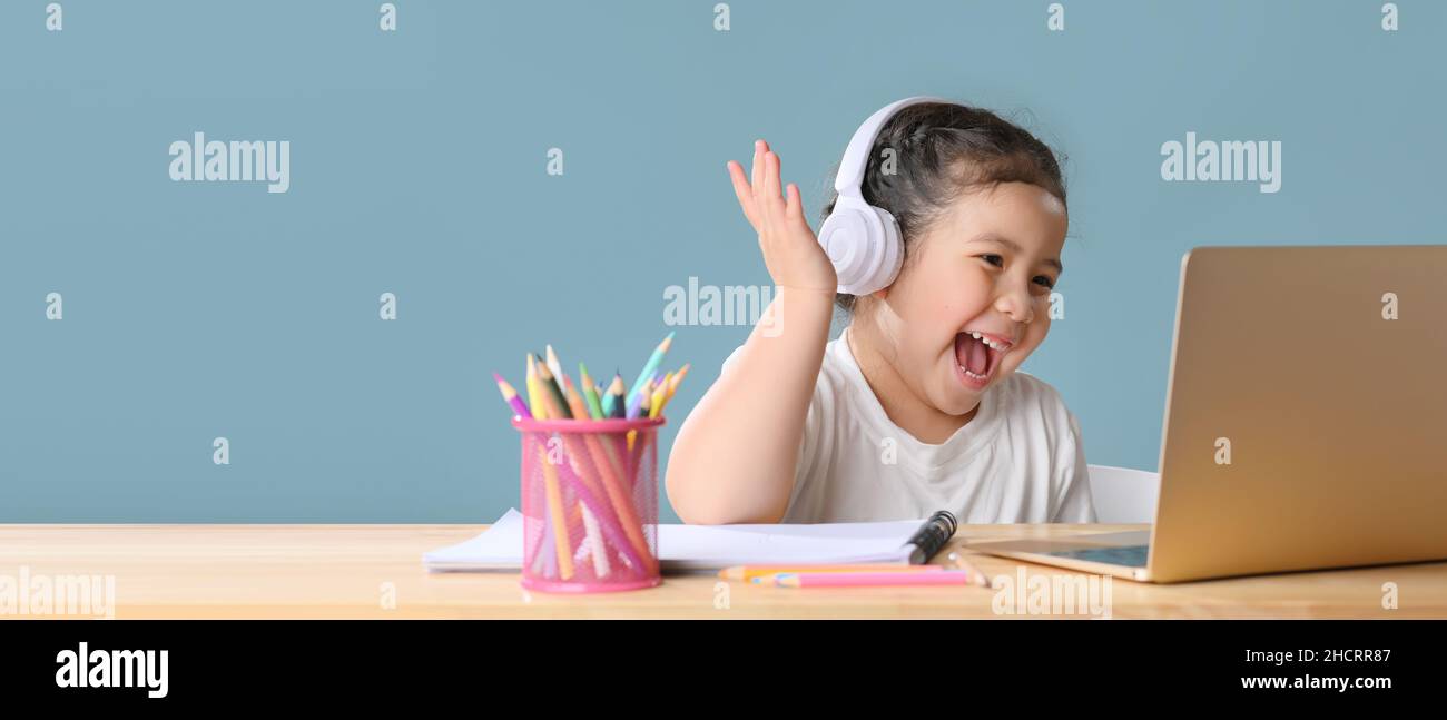 A Happy little asian girl studying online learning class with online ...