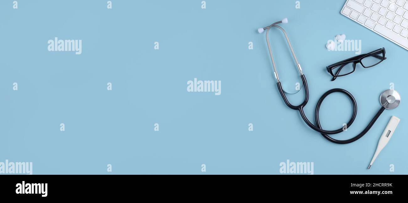 Top view of doctor desk table with stethoscope, blank paper on ...