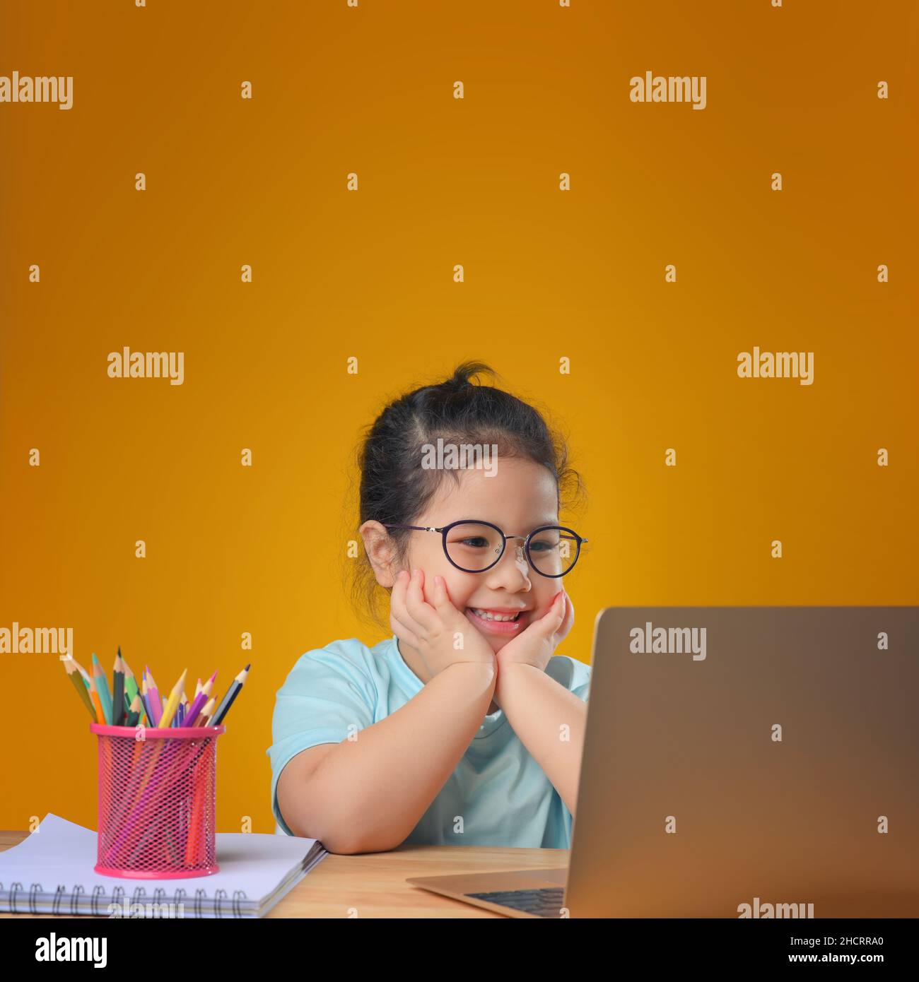 A Happy little asian girl studying online learning class with online ...