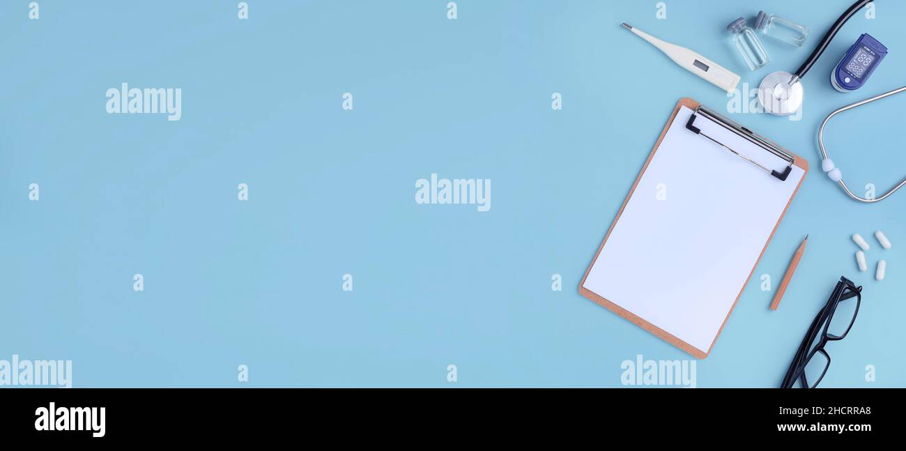 Top view of doctor desk table with stethoscope, blank paper on ...