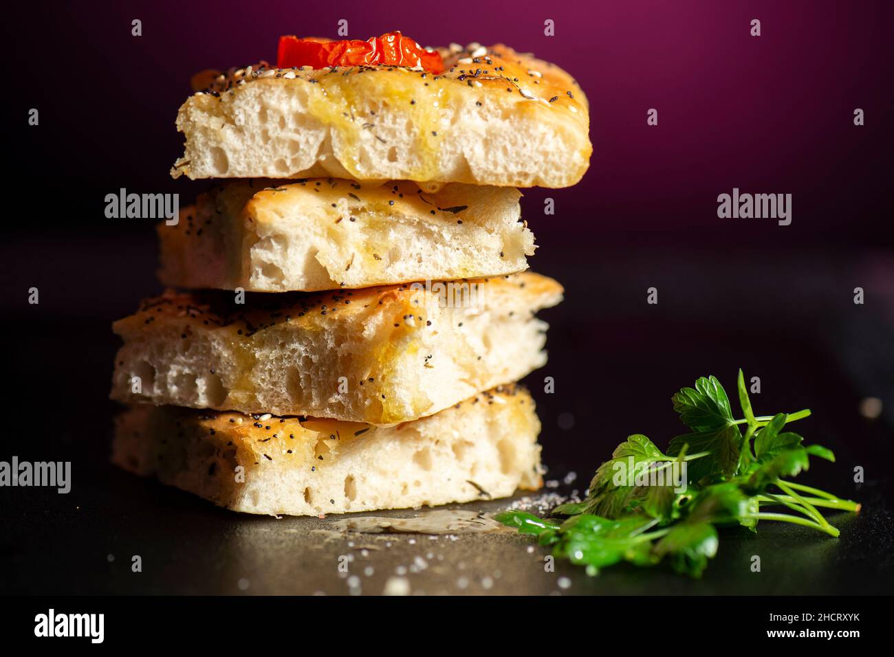 Fresh baked focaccia with cherry tomato, poppy and sesame seeds, pepper ...