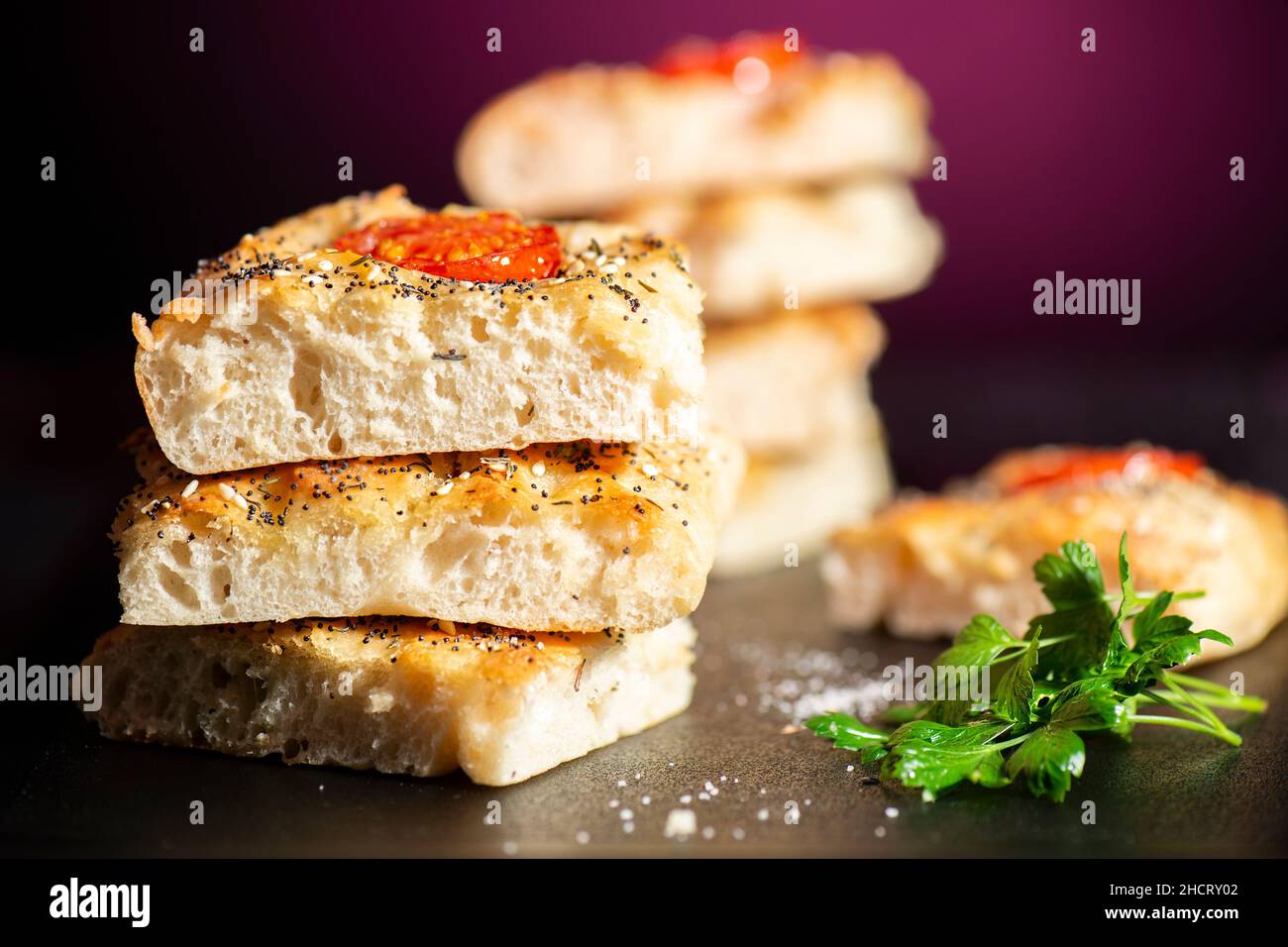 Fresh baked focaccia with cherry tomato, poppy and sesame seeds, pepper ...