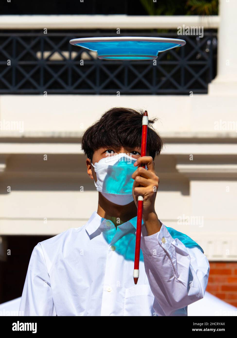 Teenage boy practices spinning and juggling plates for a public ...