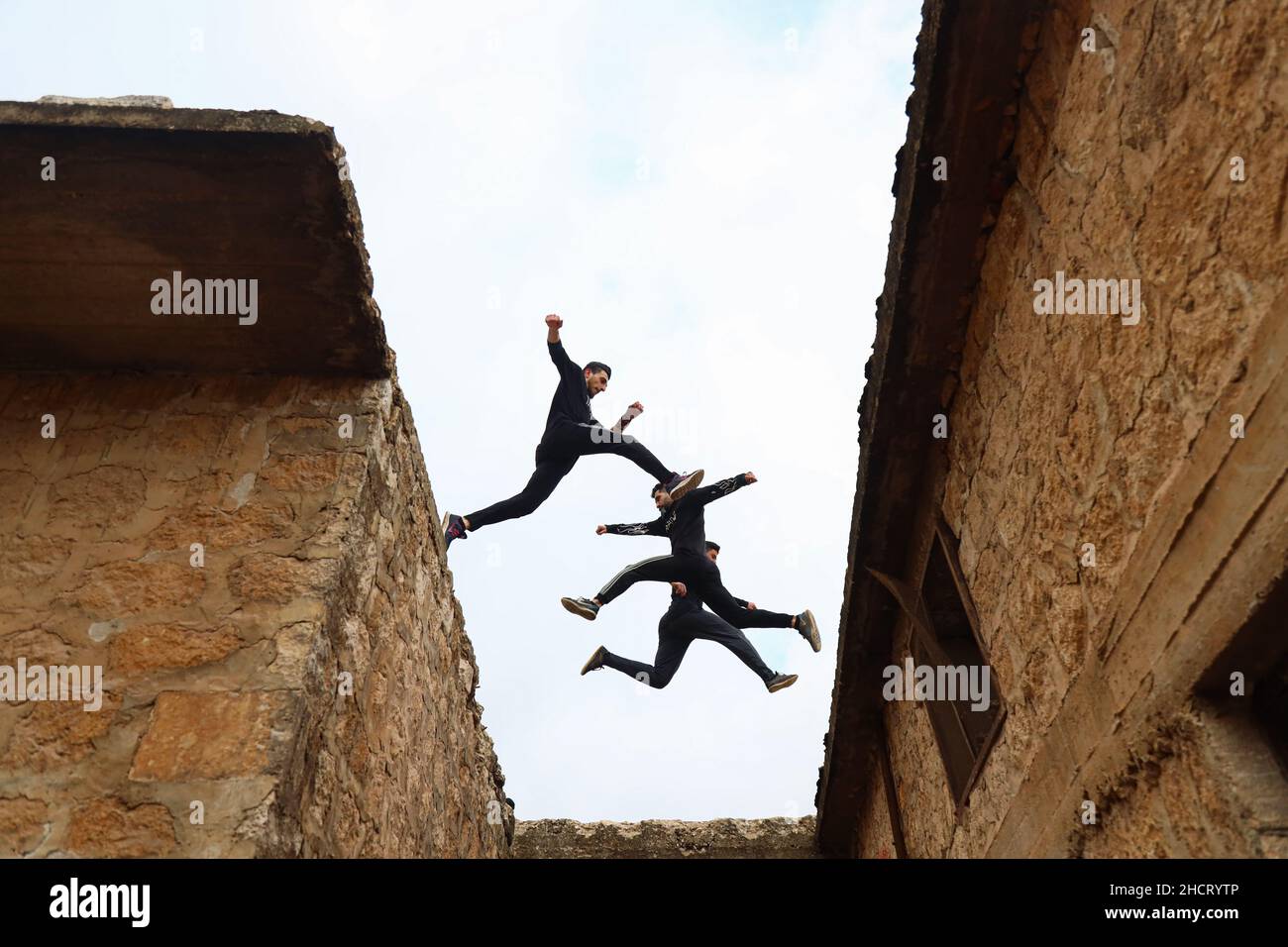 A group of young men practice their Parkour skills between the ...