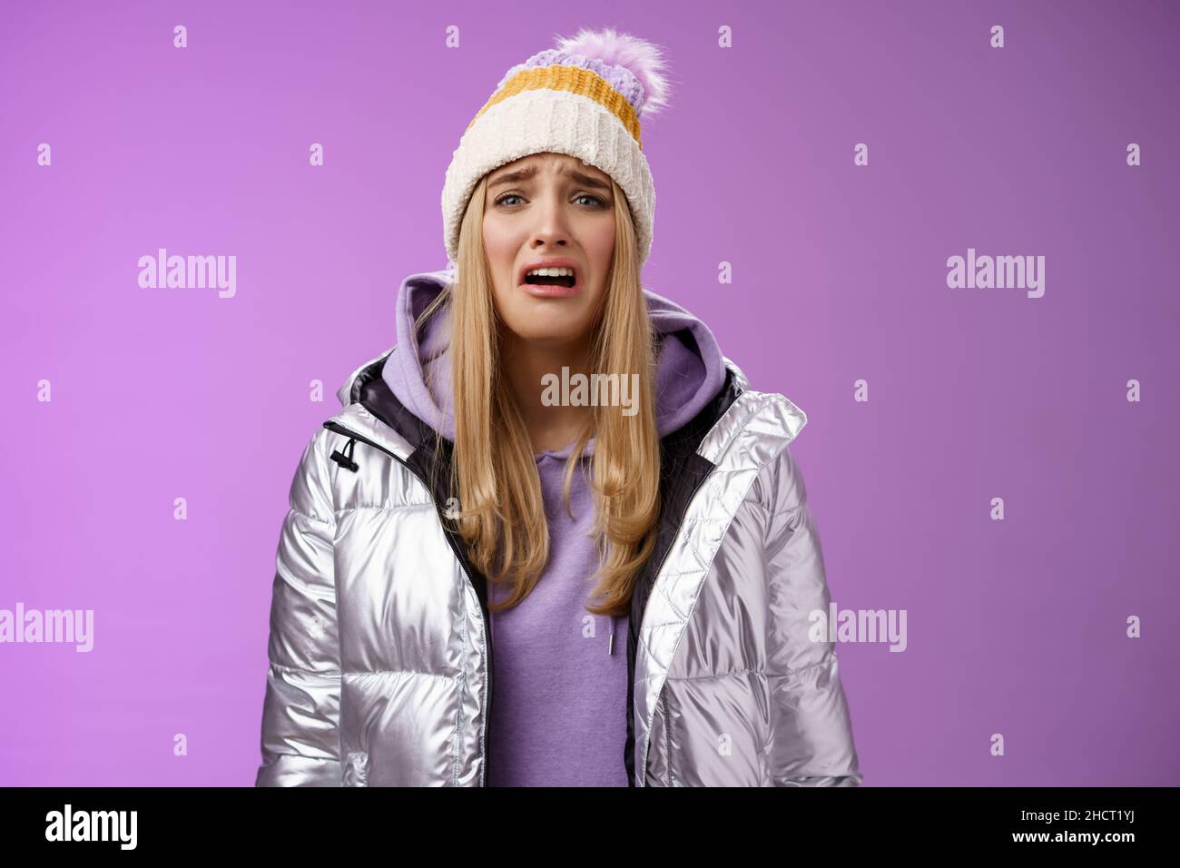 Upset sobbing miserable cute blond woman in silver stylish jacket hat ...