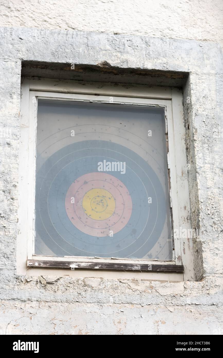A riddled target behind an old window Stock Photo - Alamy