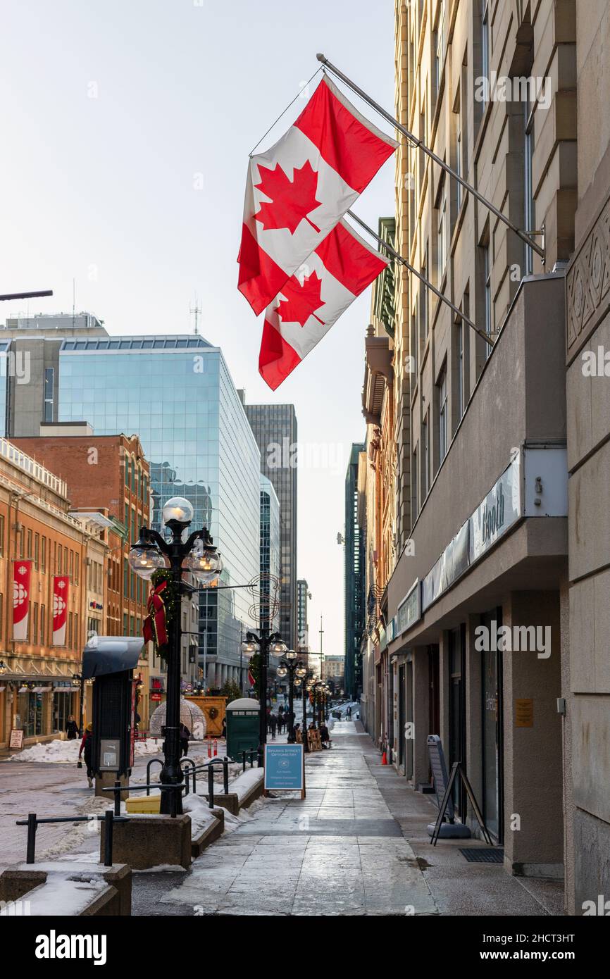 Ottawa, Canada - December 16, 2021: Cityscape street view with canadian flags on buildings in ...