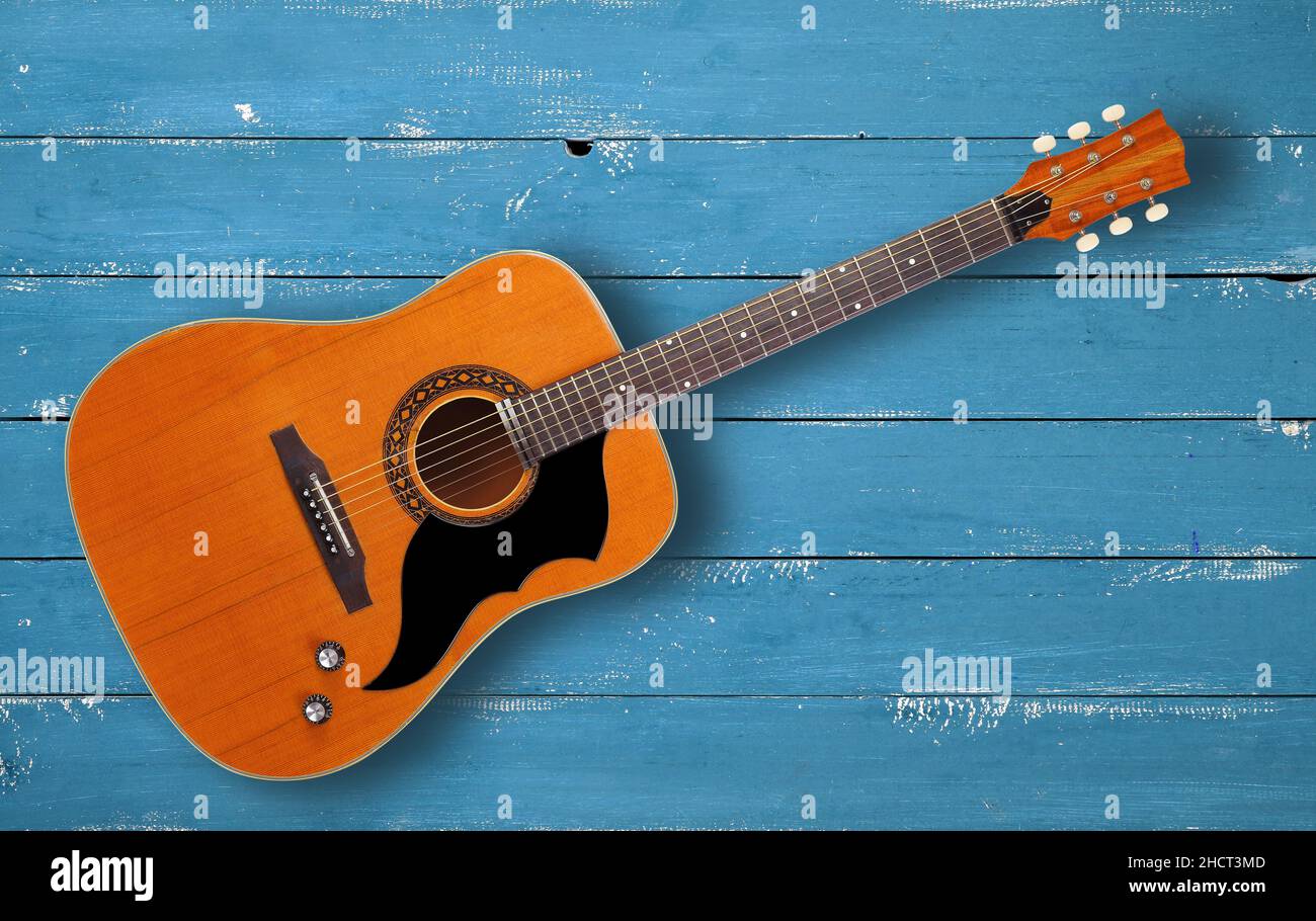 Musical instrument - Top view vintage western acoustic guitar on a blie ...