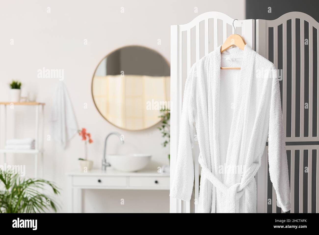 Folding screen with bathrobe in interior of modern bathroom Stock Photo ...