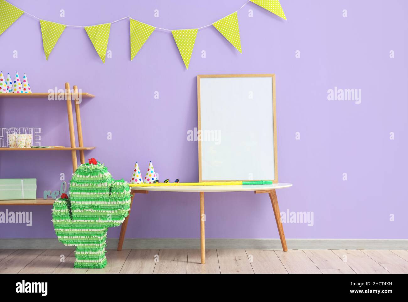 Interior of stylish room with Mexican pinata, table and shelving unit ...