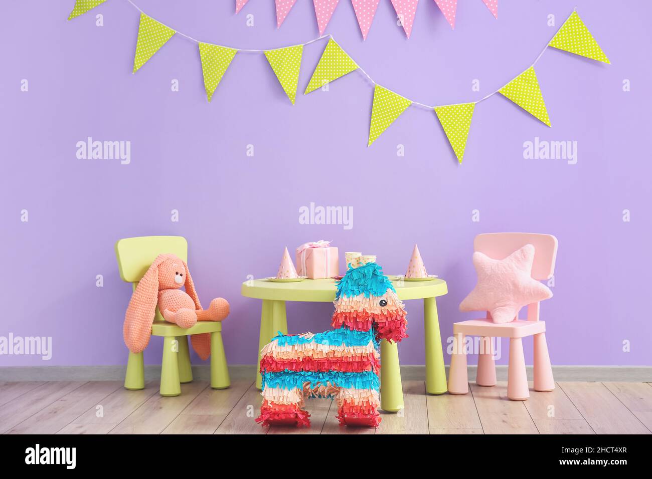 Interior of children's room with table, chairs and Mexican pinata ...