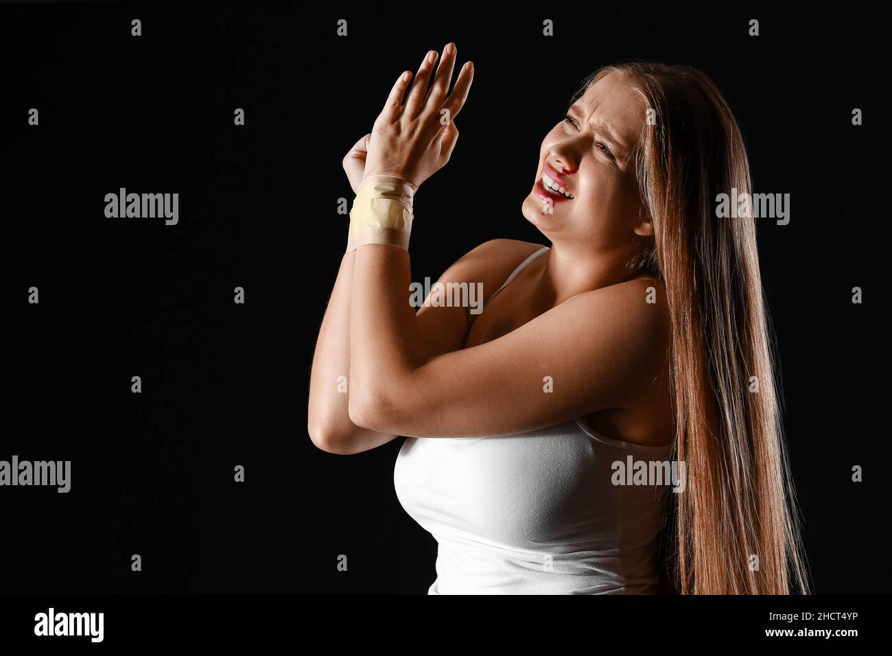 Scared woman with tied hands on dark background. Violence concept Stock ...