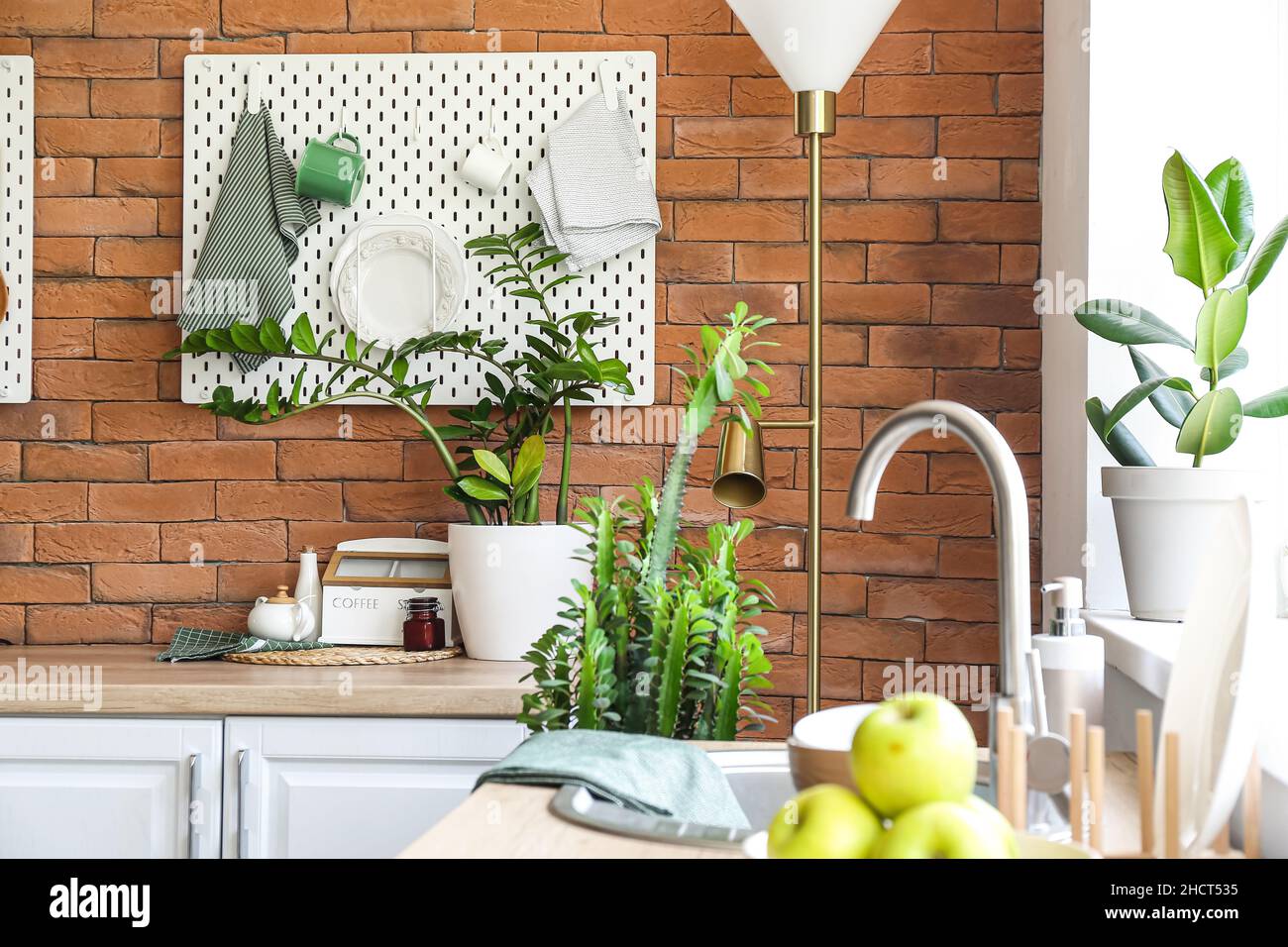 Peg board with kitchenware hanging on brick wall Stock Photo - Alamy