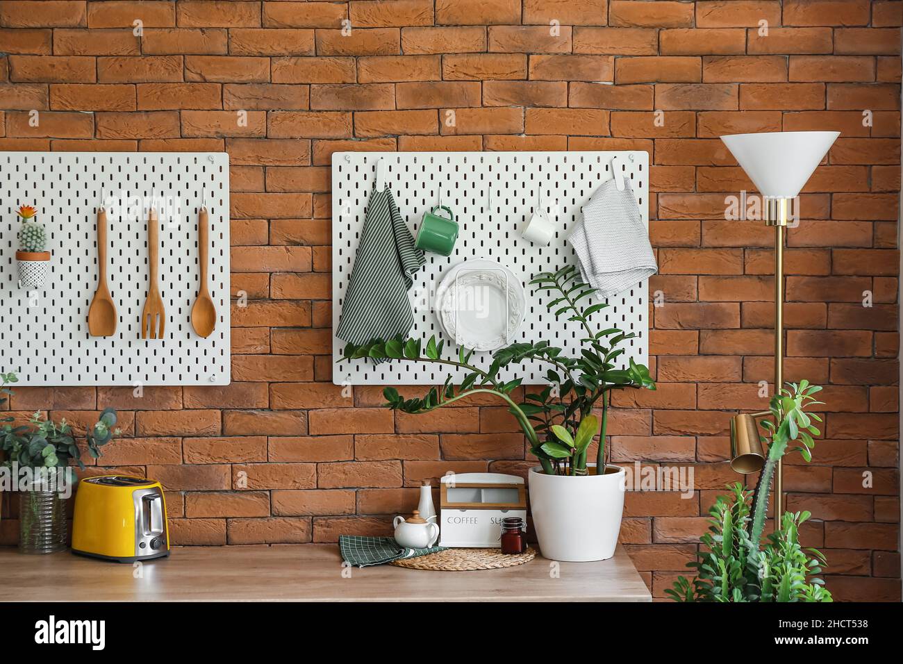 Peg boards with kitchenware hanging on brick wall Stock Photo - Alamy
