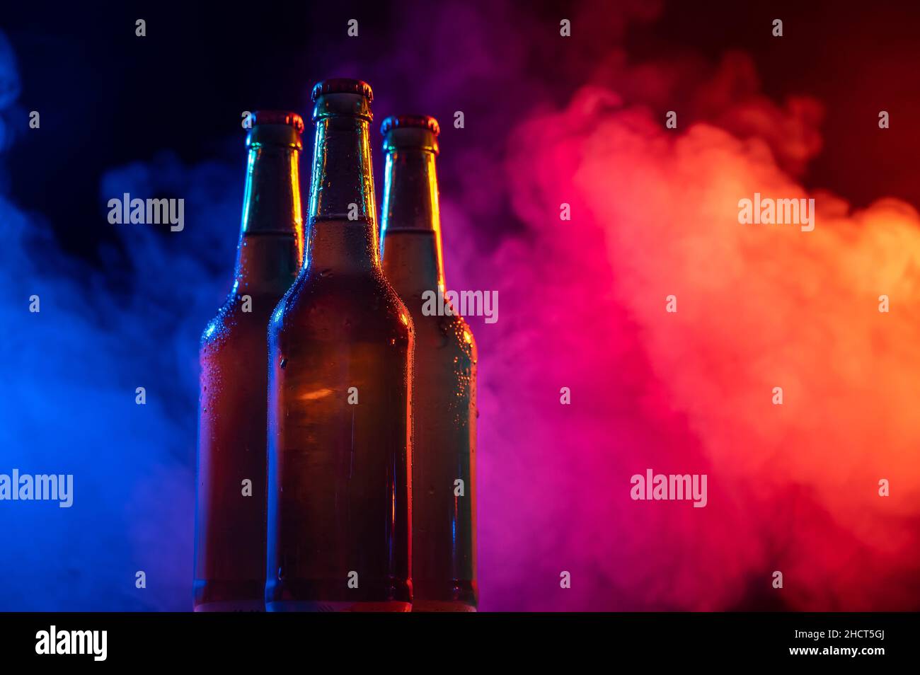 Three bottles of beer in a blue-pink mist Stock Photo - Alamy