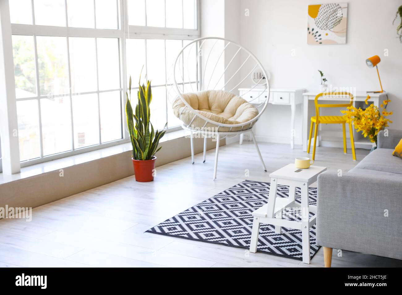 White step stool with cup near sofa in living room Stock Photo - Alamy