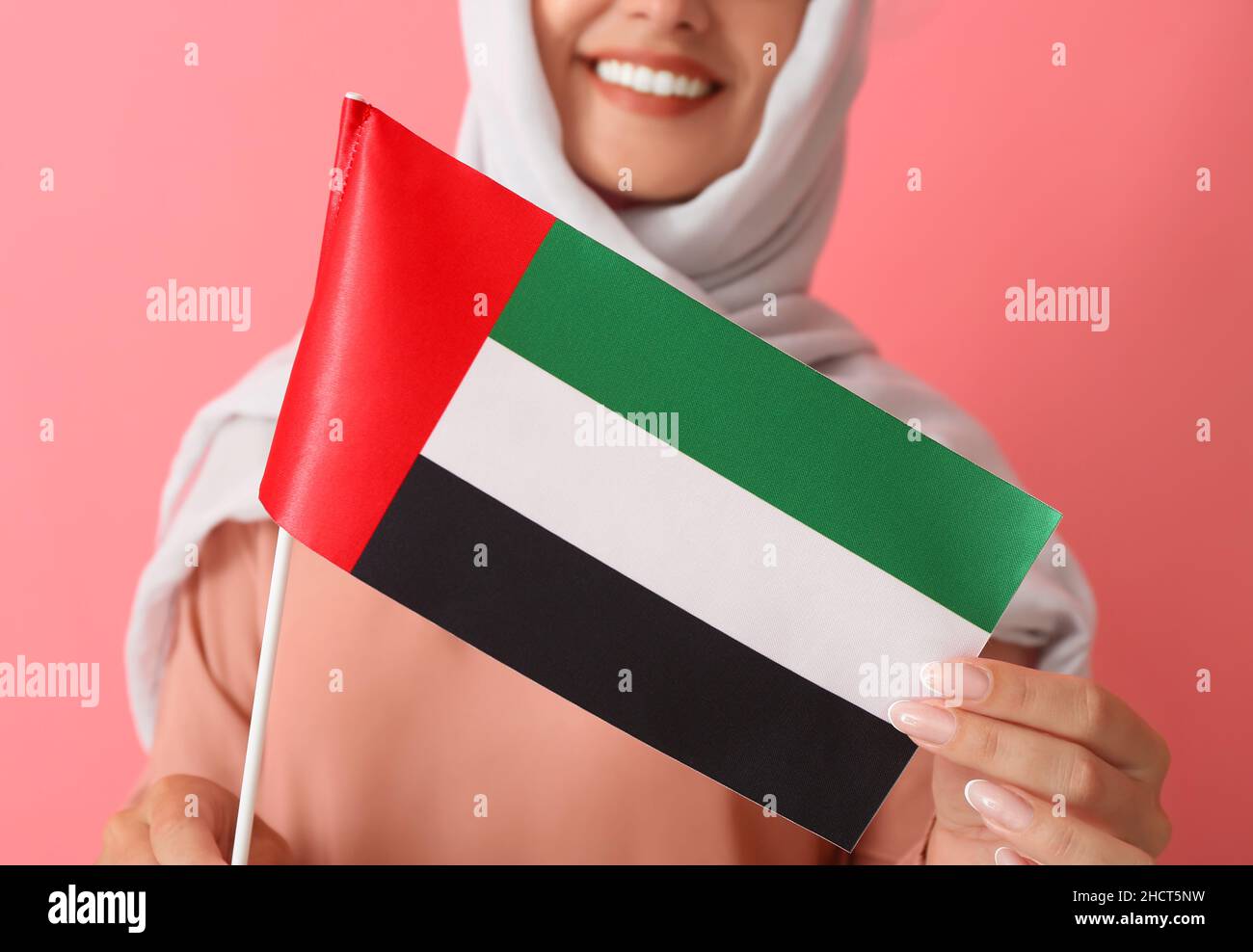 Young woman in traditional clothes and with the national flag of UAE on ...