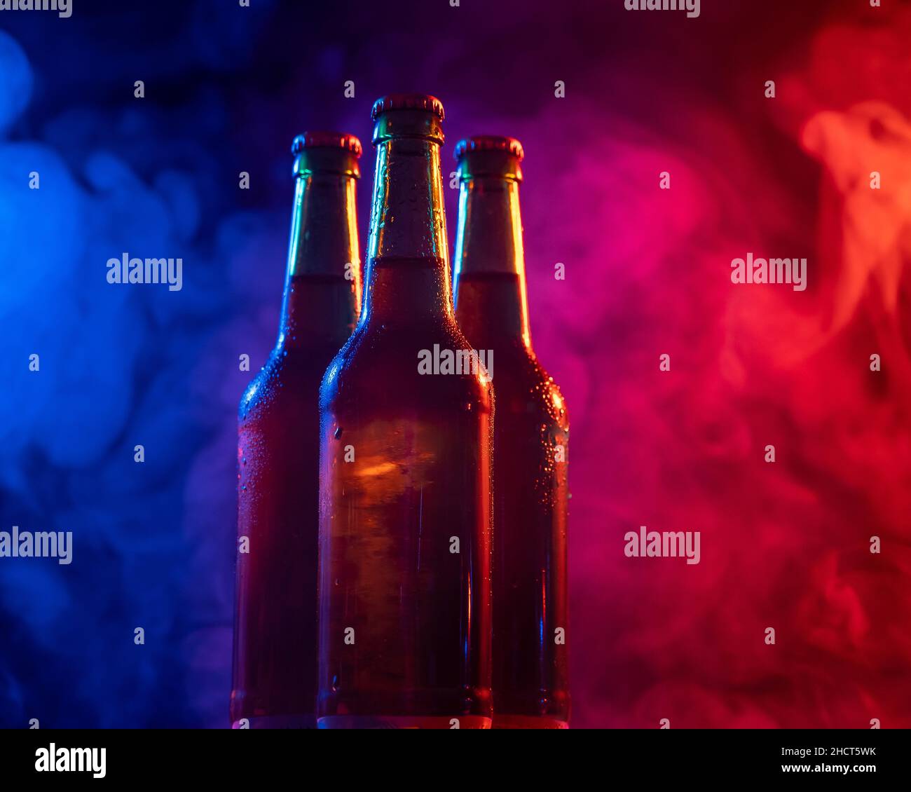 Three bottles of beer in a blue-pink mist Stock Photo - Alamy