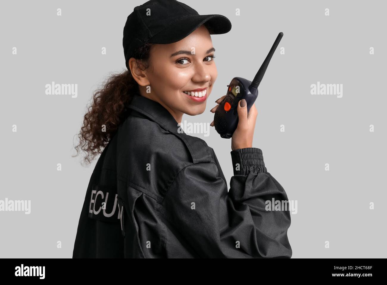 African-American female security guard with radio transmitter on light ...