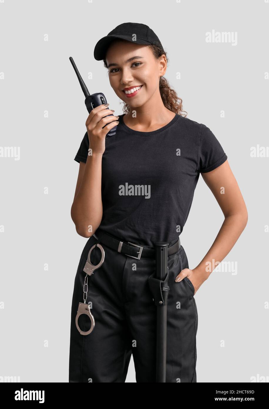 African-American female security guard with radio transmitter on light ...