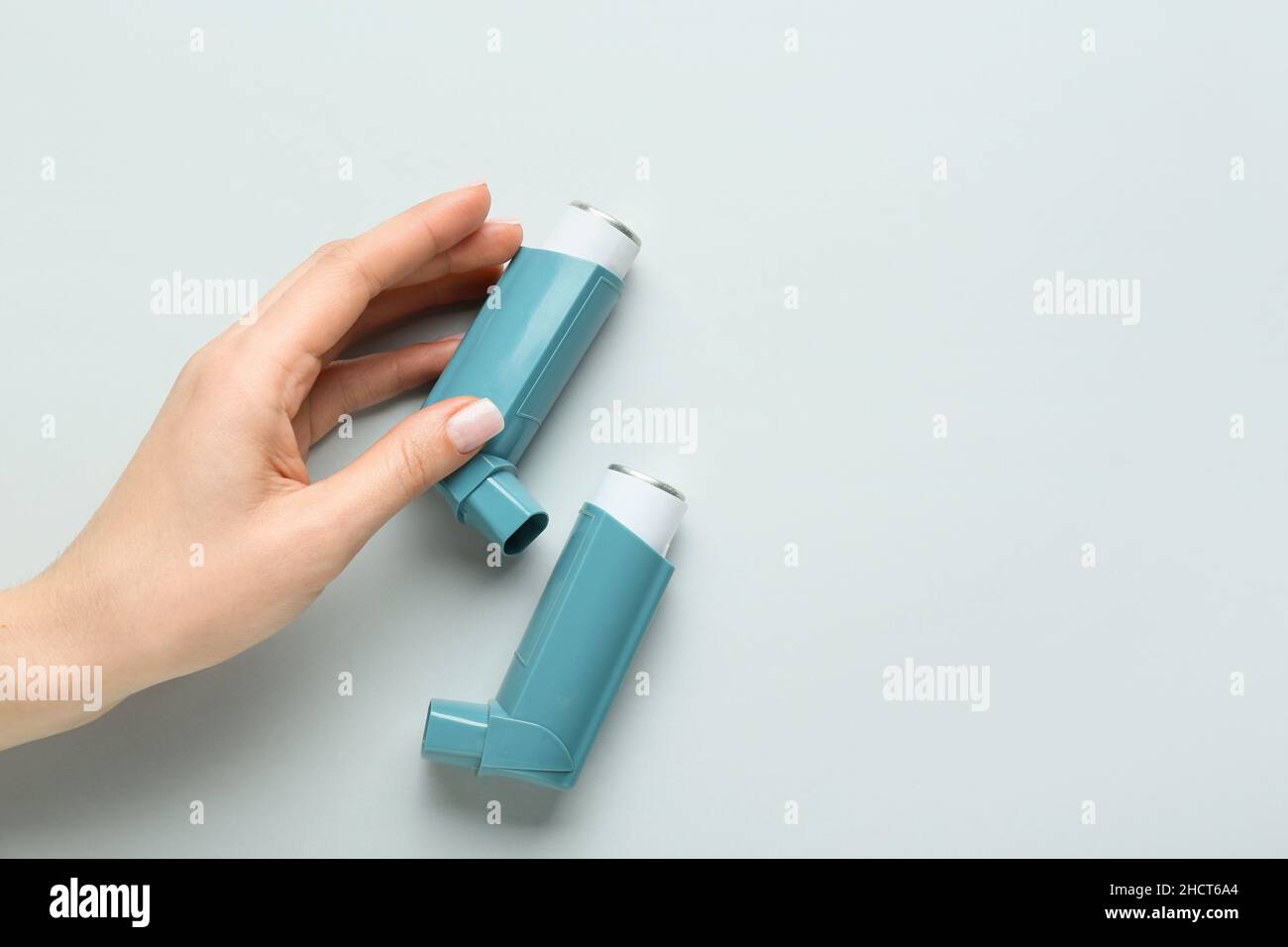 Female hand with modern asthma inhalers on grey background Stock Photo ...