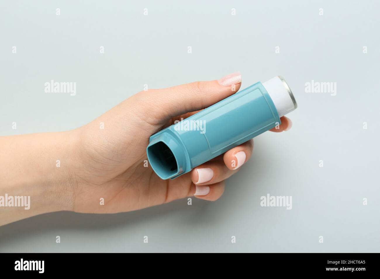 Female hand with modern asthma inhaler on grey background Stock Photo ...