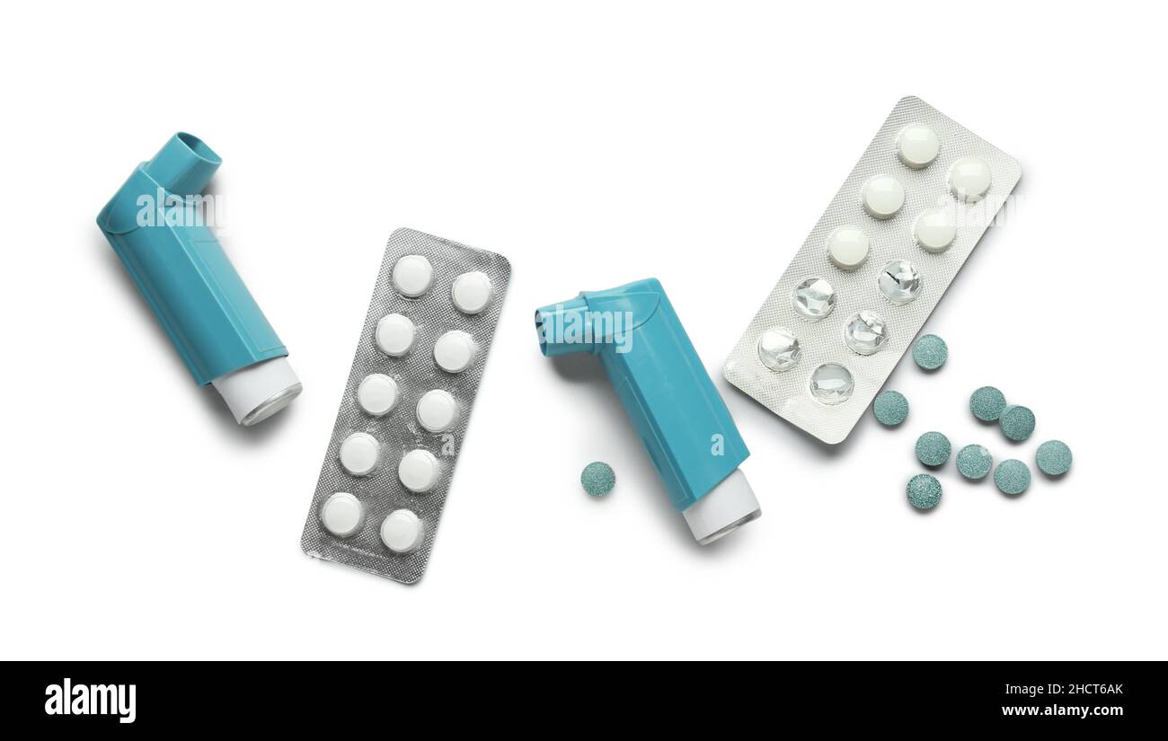 Modern asthma inhalers and blister packs of pills on white background ...