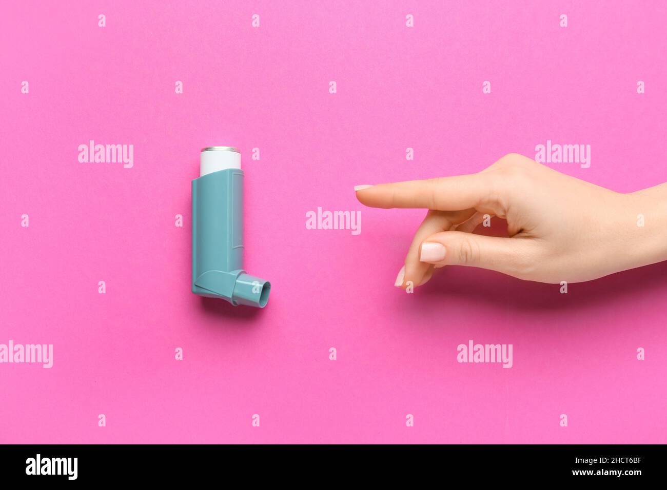 Female hand pointing at asthma inhaler on color background Stock Photo ...