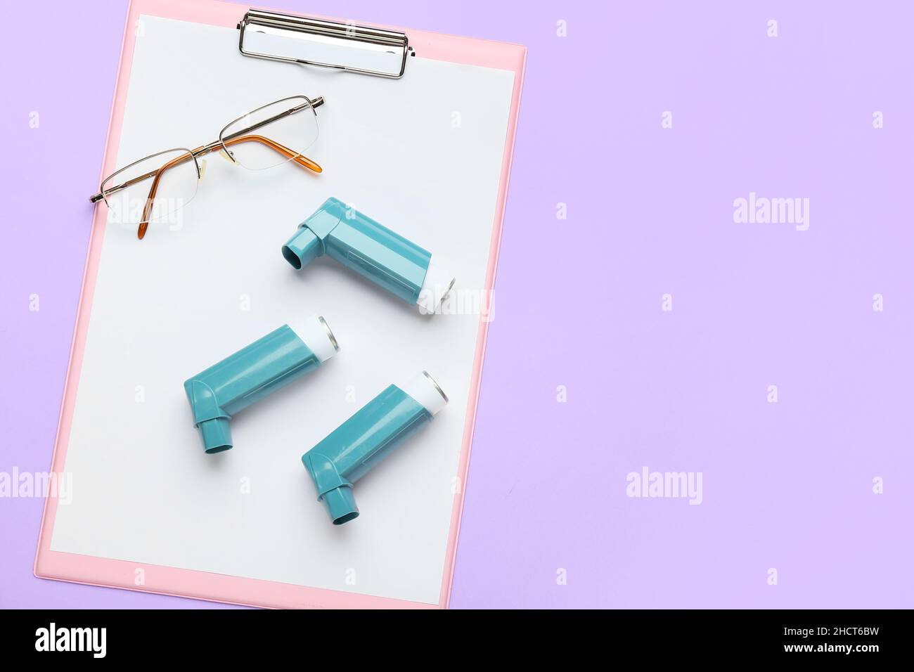 Clipboard, eyeglasses and asthma inhalers on color background Stock ...