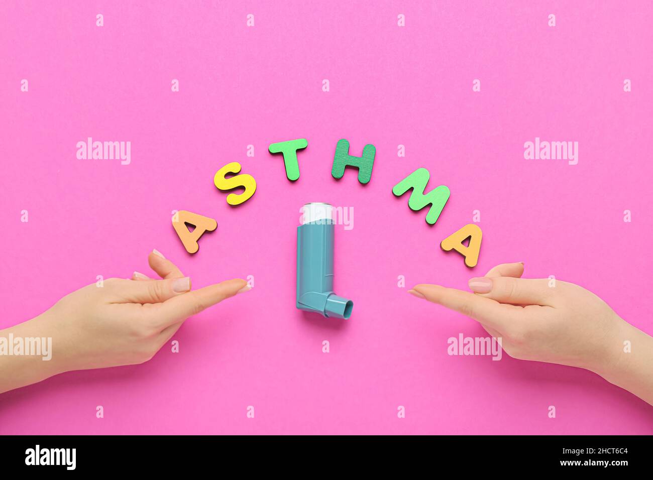 Female hands pointing at inhaler and word ASTHMA on color background ...